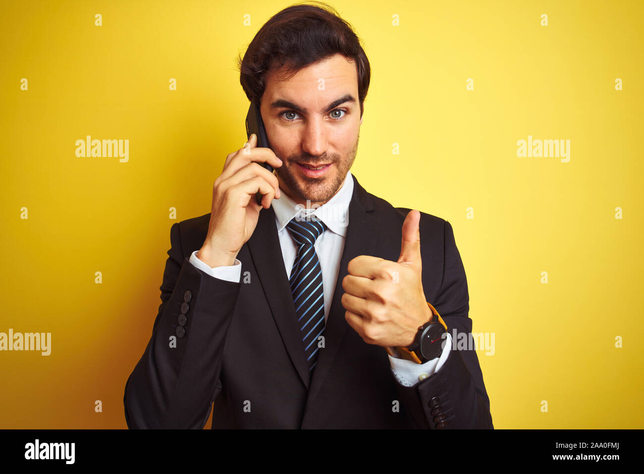 Young handsome businessman talking on the smartphone over isolated ...