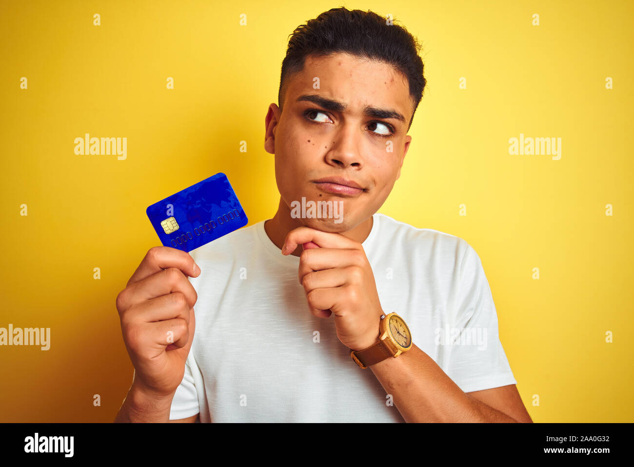Young brazilian customer man holding credit card standing over isolated ...