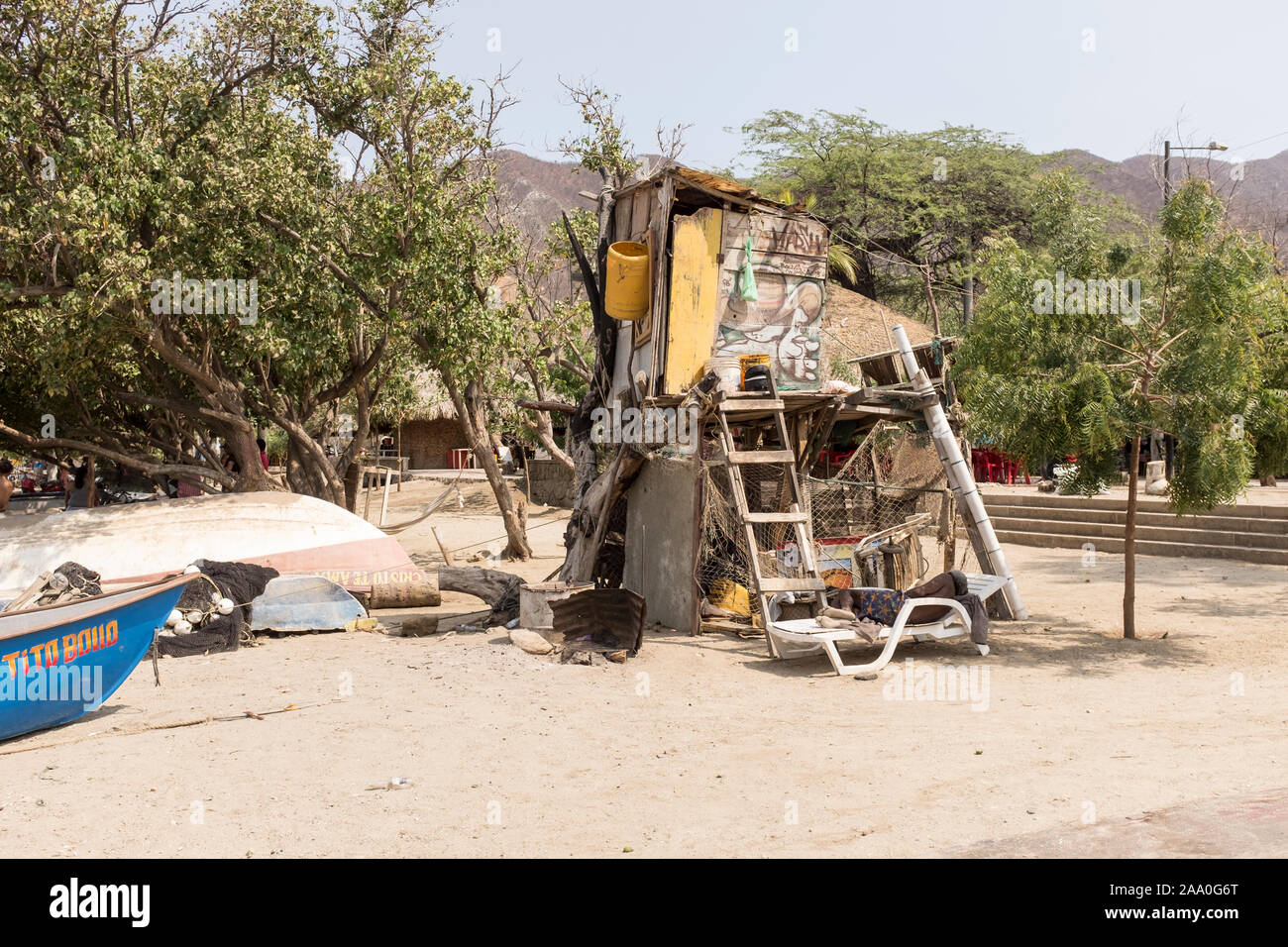 A fisherman takes a nap outside a makeshift hut made of driftwood and ...