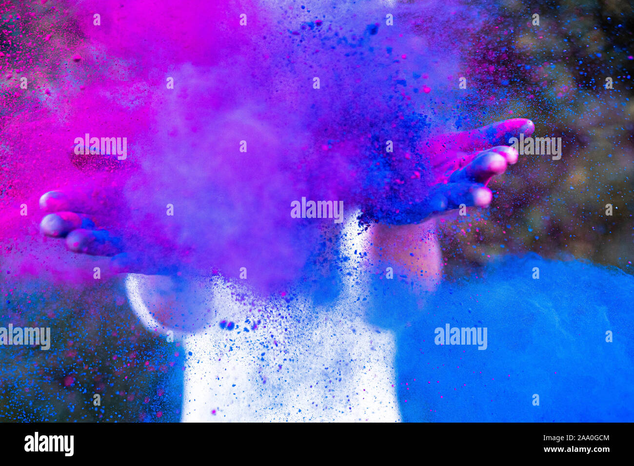 Young woman plays with colors, creating a colour explosion with blue a ...