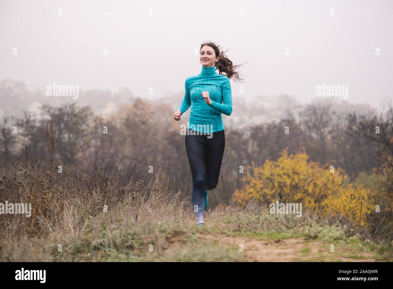 Pretty woman jogging in autumn morning forest. Female walking running ...