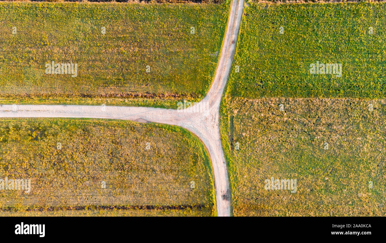 Drop down view of dirt road T-junction surrounded with fields Stock ...