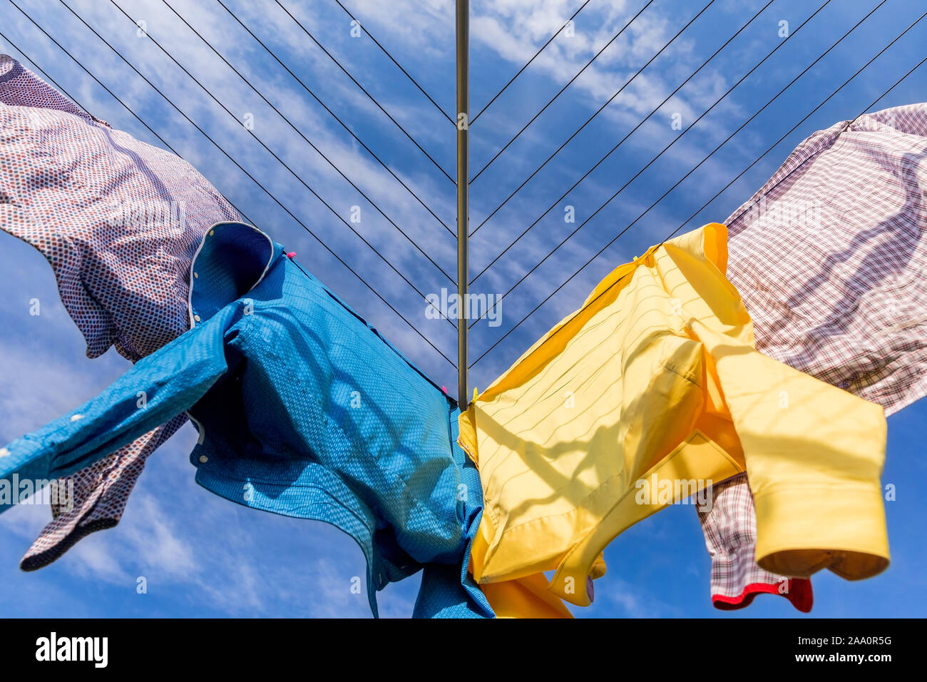 Colorful fresh laundry hanging outside on clothes line or dry washing ...