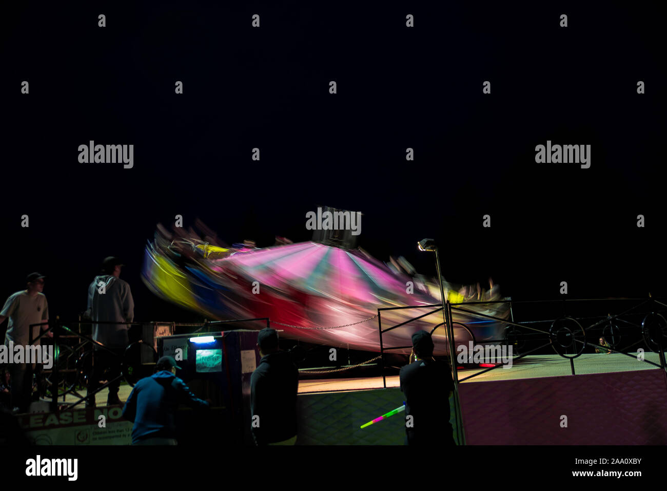 Spinning carnival ride at fair. Fast movement blurred fairground ...