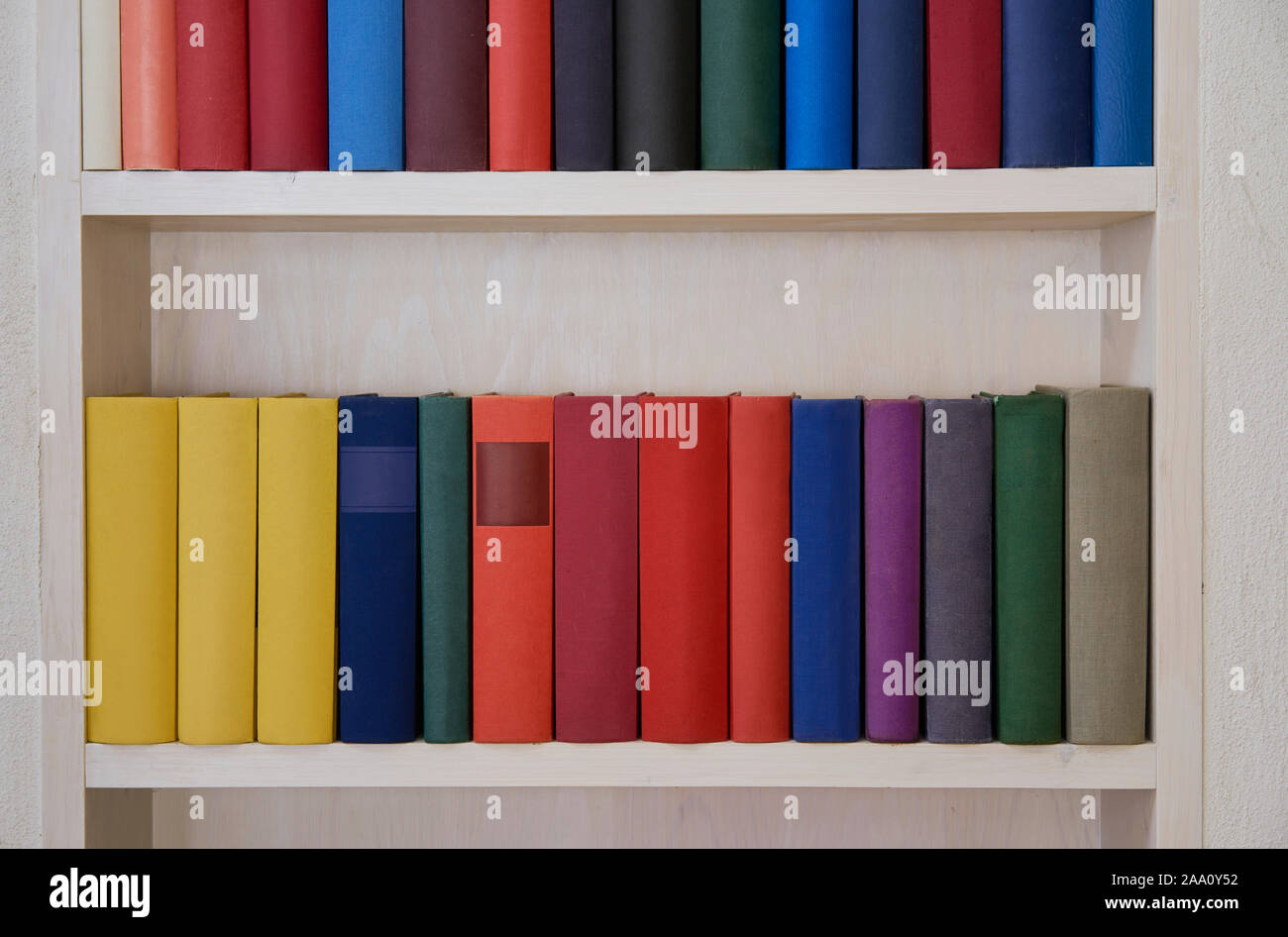 Part of bookcase with colorful covers in white wall Stock Photo - Alamy