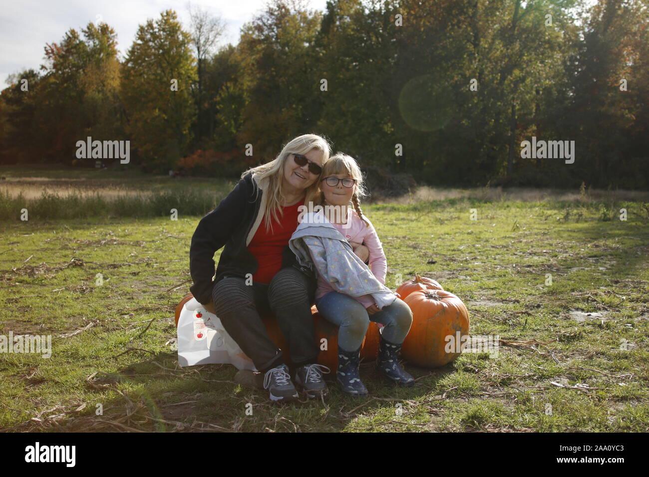 Grandma and granddaughter at a pumpkin patch enjoying the fall activity ...