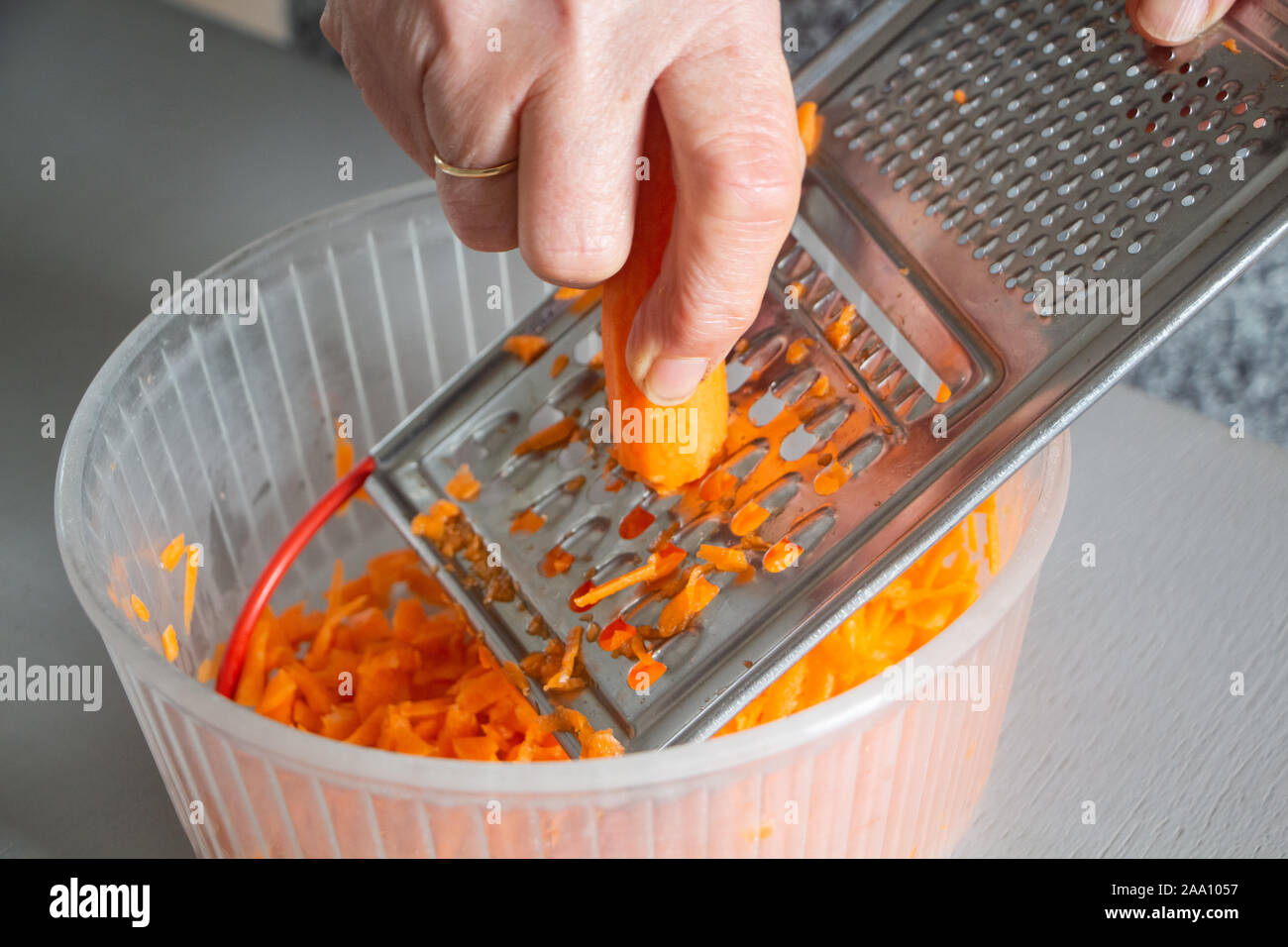 Hand of a woman grating carrot with a grater Stock Photo - Alamy