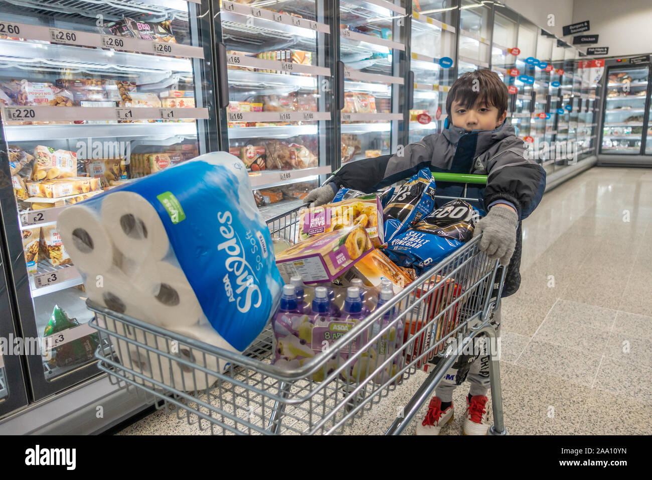 A young boy pushes a trolley around a supermarket Stock Photo - Alamy