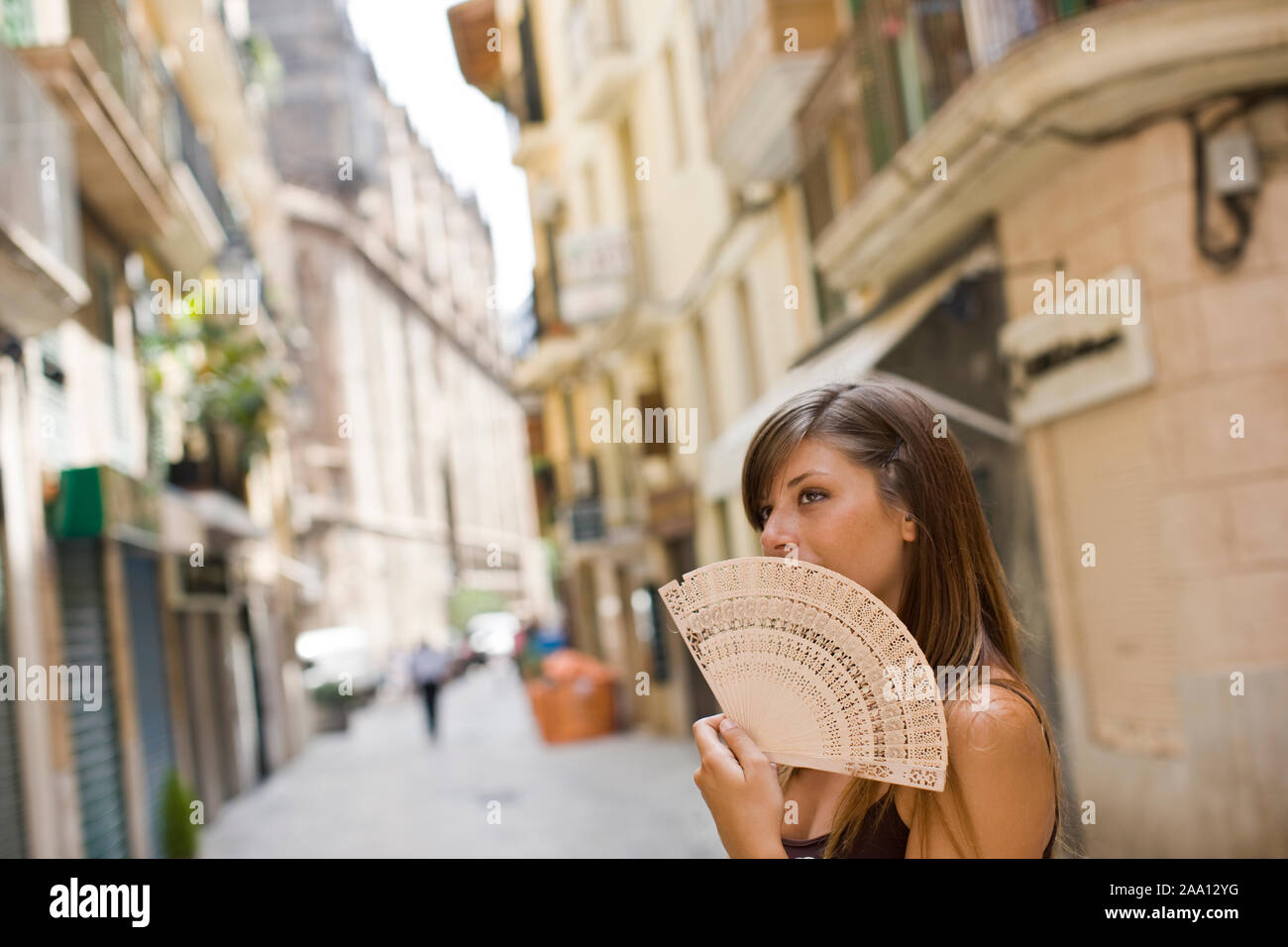 Young adult female hiding her face behind a fan Stock Photo - Alamy