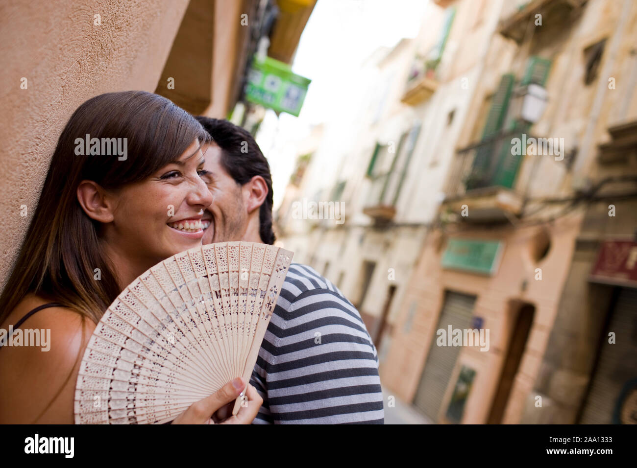 Young adult couple hugging behind a fan Stock Photo - Alamy