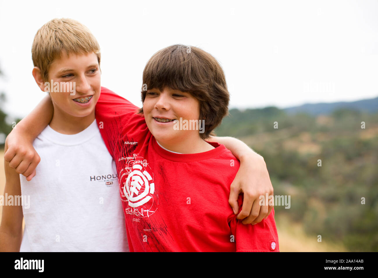 Two smiling boys standing with an arm around each other Stock Photo - Alamy