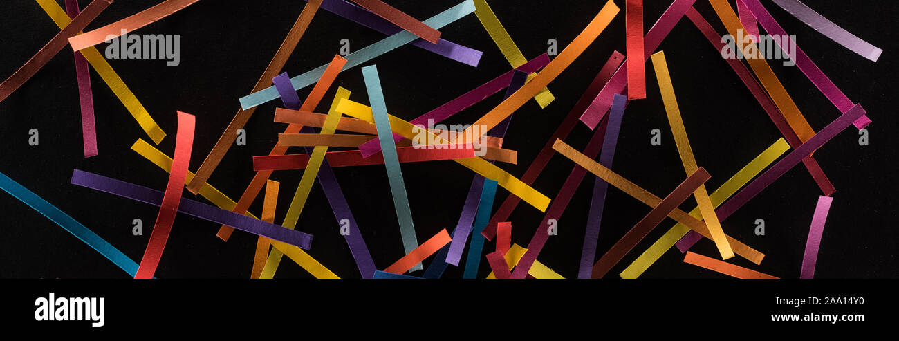 top view of multicolored abstract lines scattered isolated on black ...