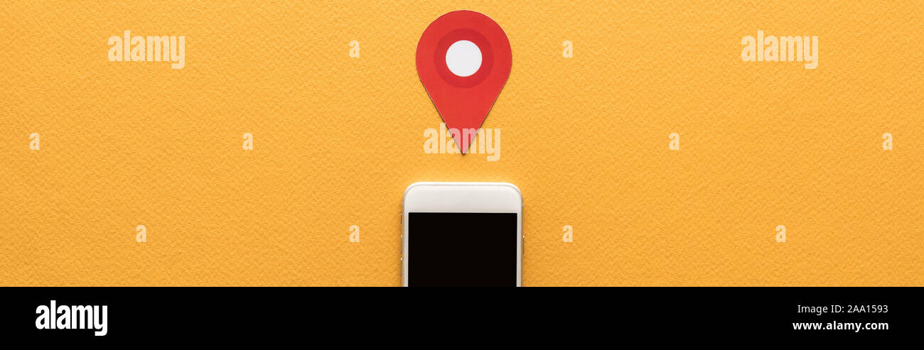 top view of paper cut location mark near smartphone with blank screen ...