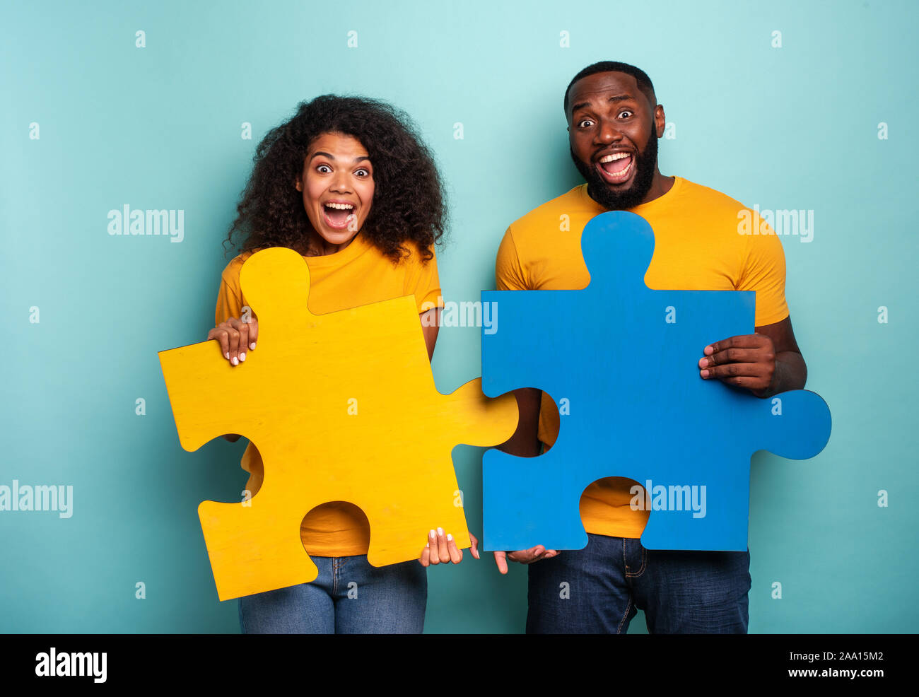 Couple with puzzles in hand over light blue background. Concept of ...