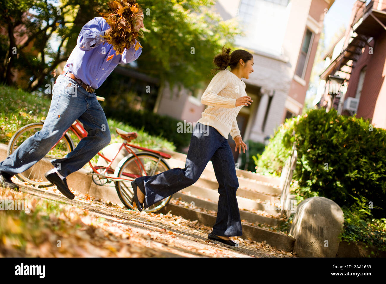 Young man running after his girlfriend with a pile of leaves Stock ...