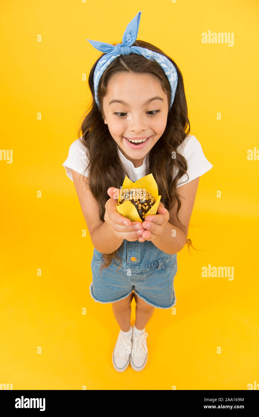 Happy childhood. Kid girl hold glazed muffins. Cafe restaurant food ...