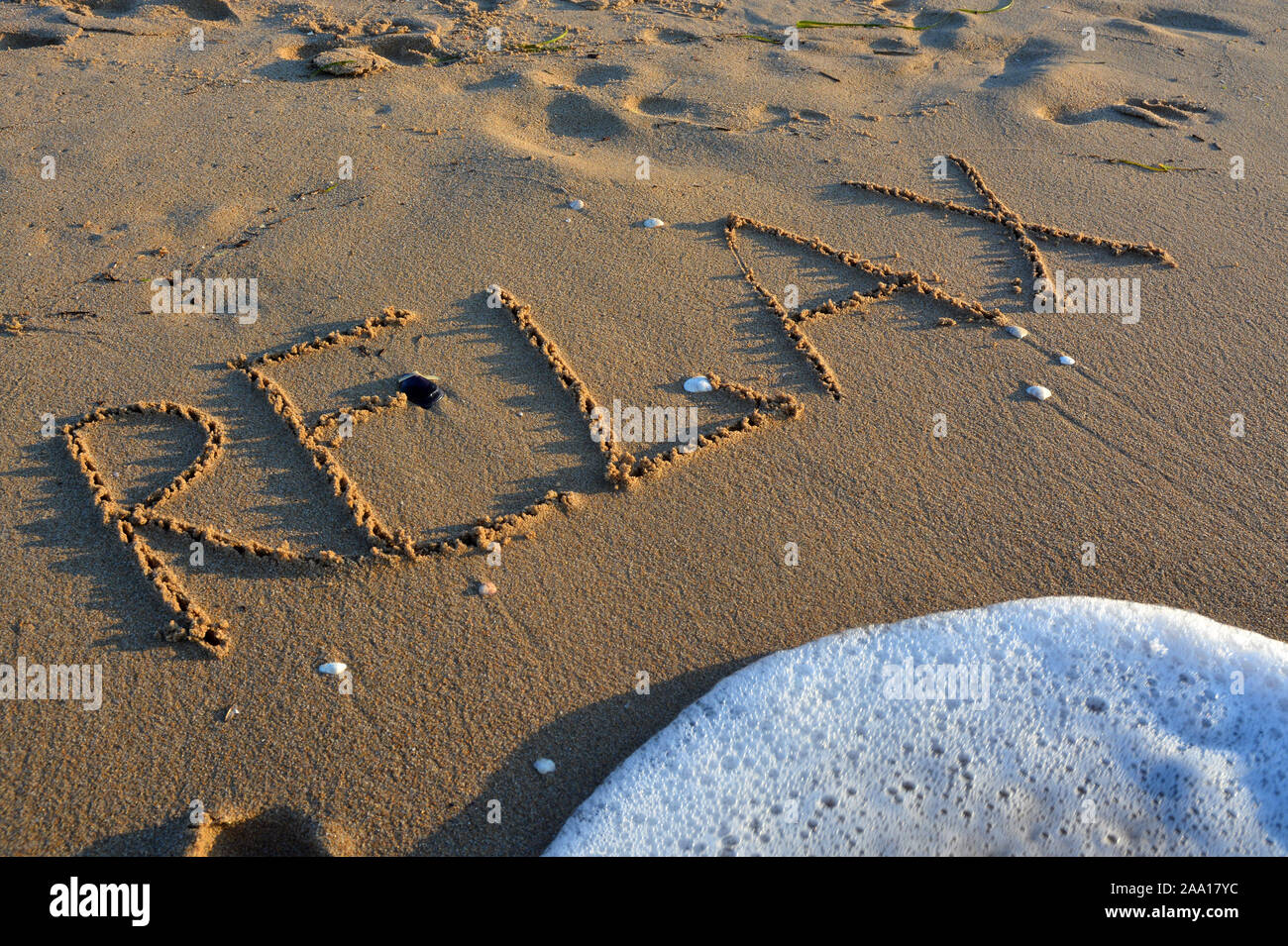 The word RELAX written on a sandy beach Stock Photo - Alamy