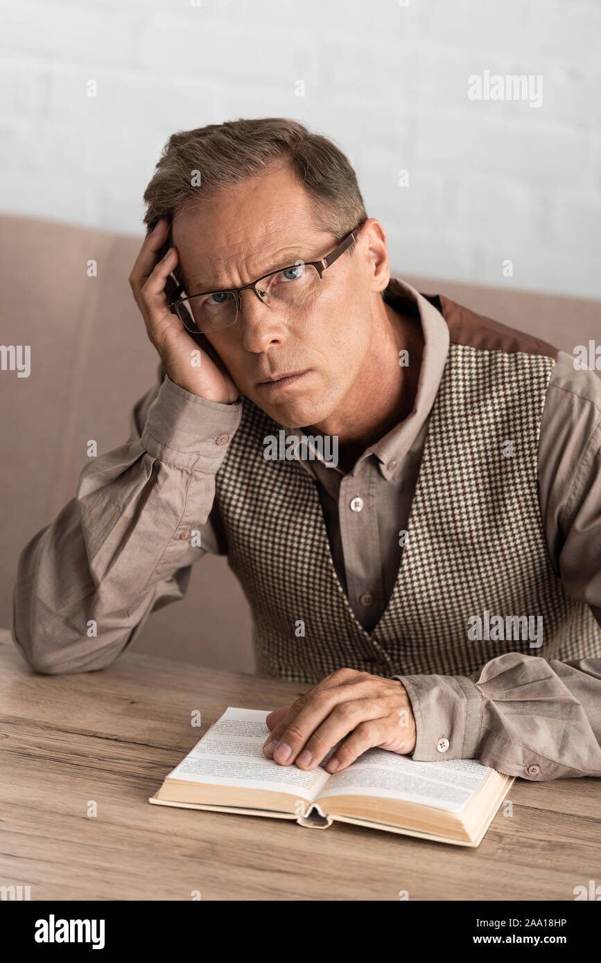 sad senior man with memory loss sitting near book Stock Photo - Alamy