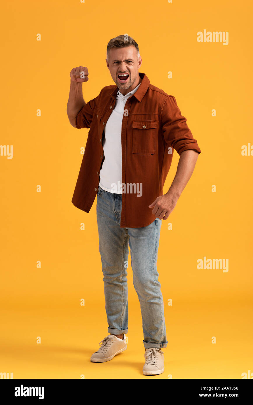 angry man with clenched fist screaming on orange Stock Photo - Alamy