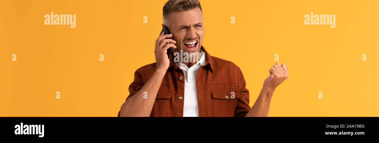 panoramic shot of angry man screaming while talking on smartphone ...
