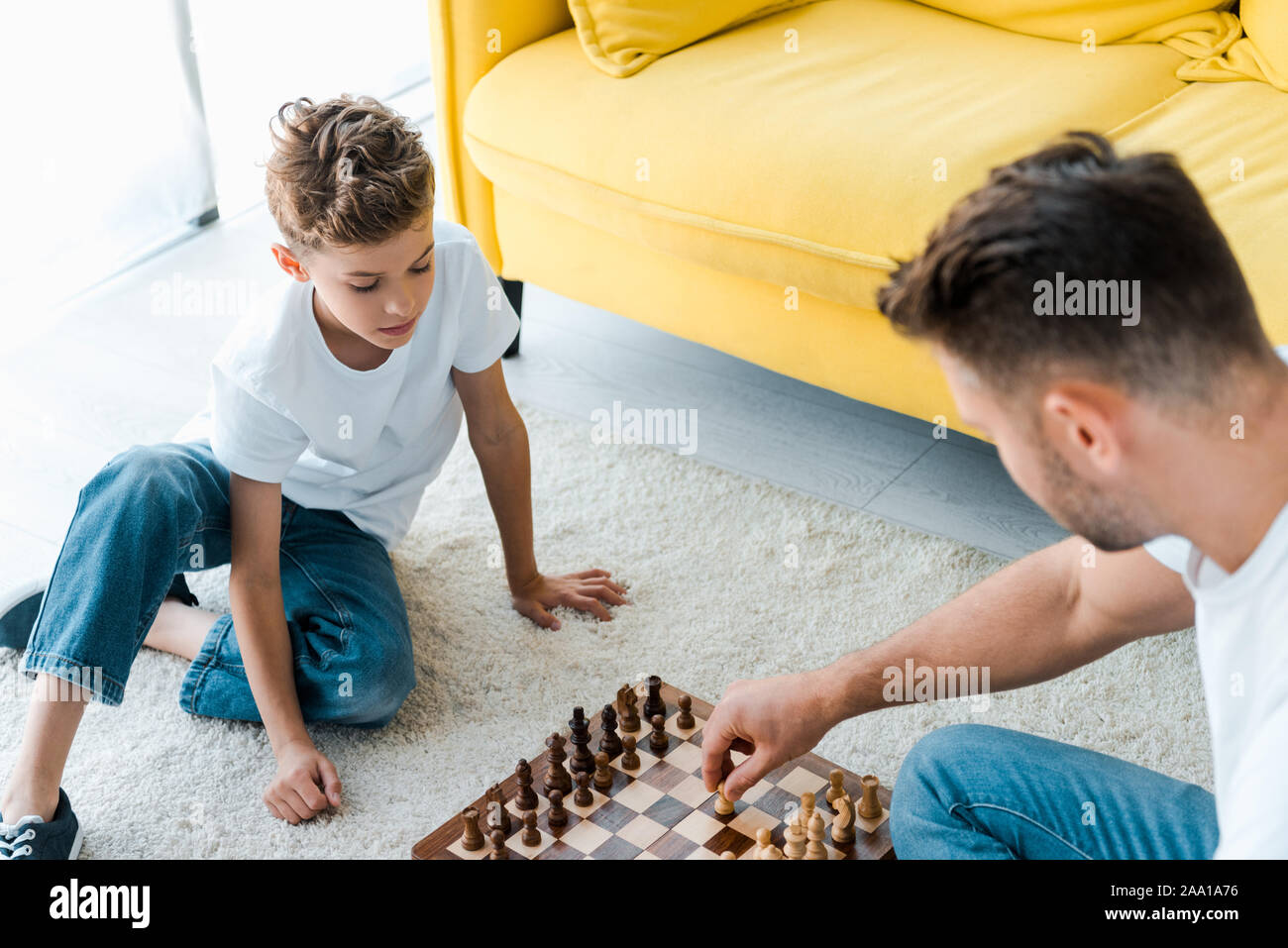 overhead view of father and son playing chess on carpet Stock Photo - Alamy