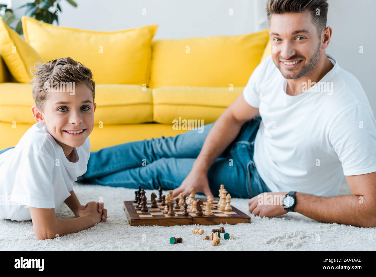 happy father and son playing chess on carpet Stock Photo - Alamy