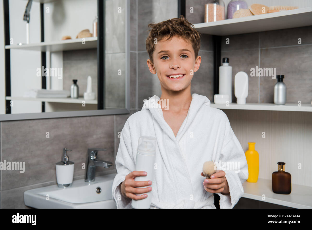 cheerful kid holding shaving brush and can with shaving foam Stock ...