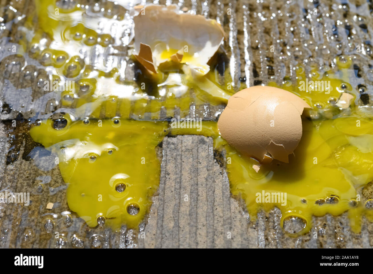 broken egg on a concrete floor Stock Photo - Alamy