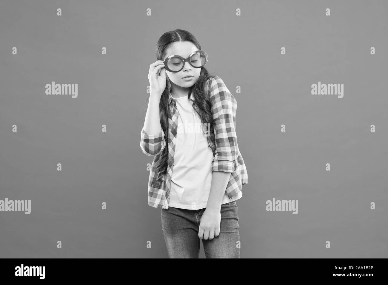 Fashionable cutie. Being smart. Little smart schoolgirl on orange ...