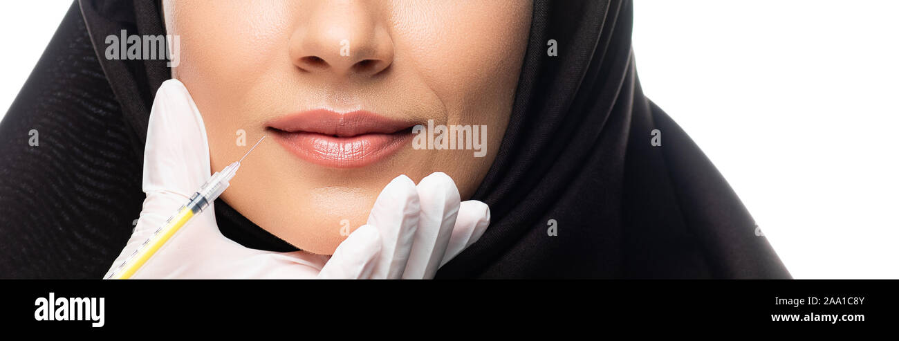 cropped view of young Muslim woman in hijab having beauty injection ...