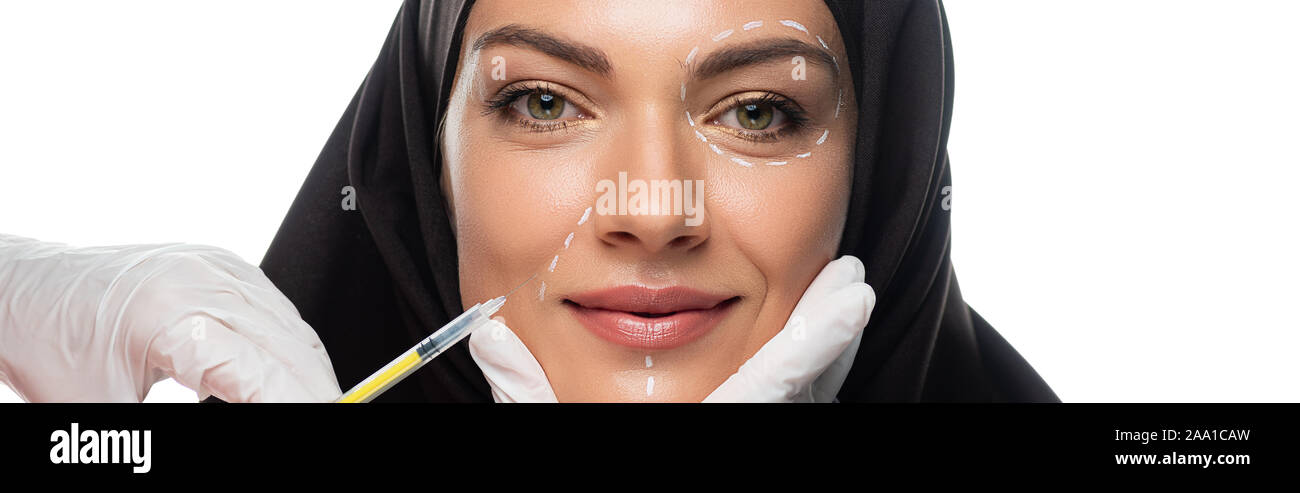 young Muslim woman in hijab with marks on face having beauty injection ...
