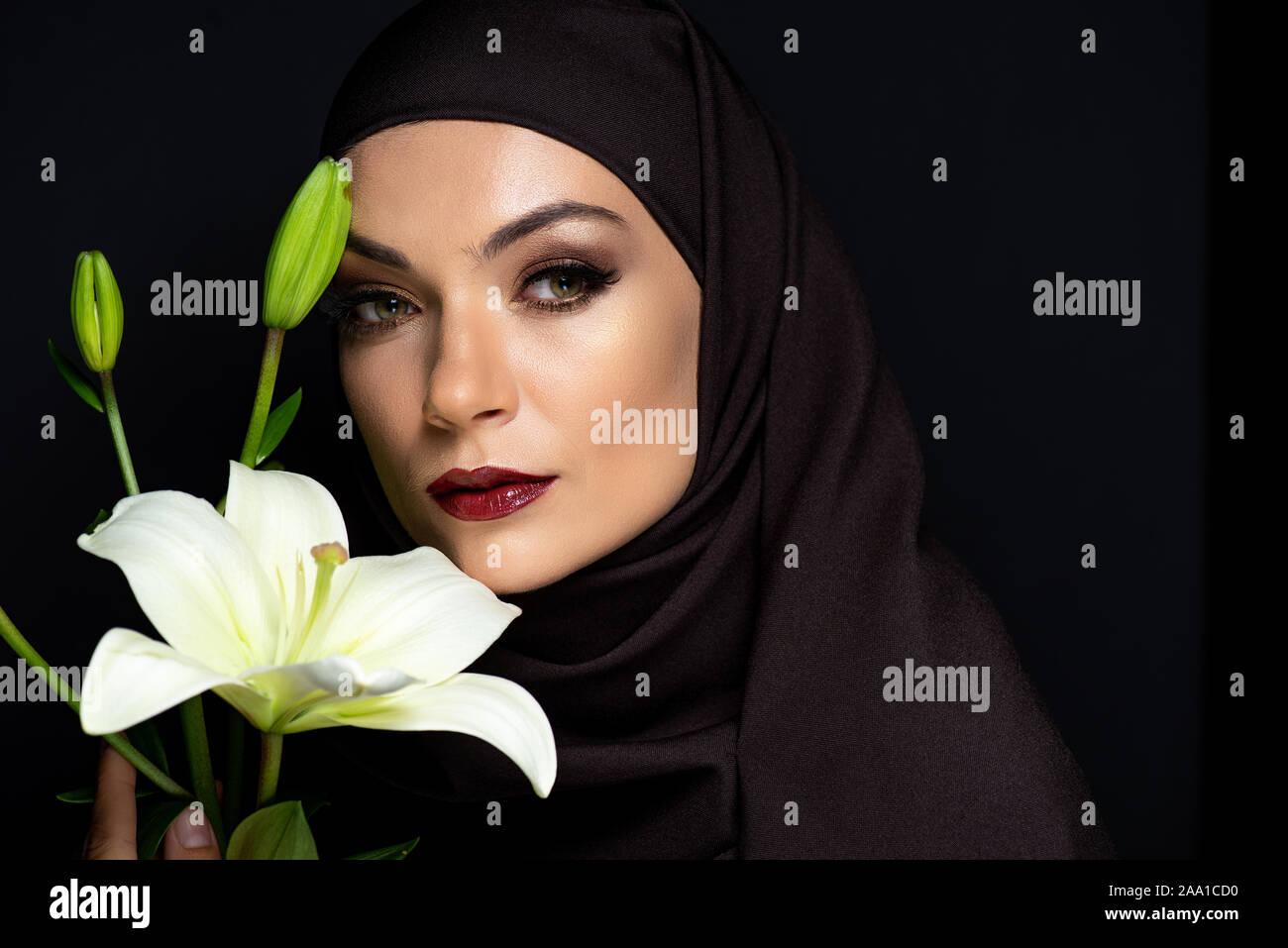 beautiful Muslim woman in hijab with smoky eyes and red lips holding ...