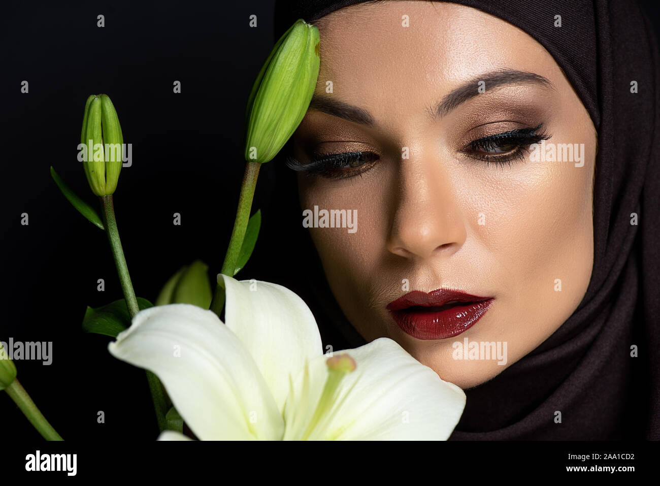 beautiful Muslim woman in hijab with smoky eyes and red lips holding ...