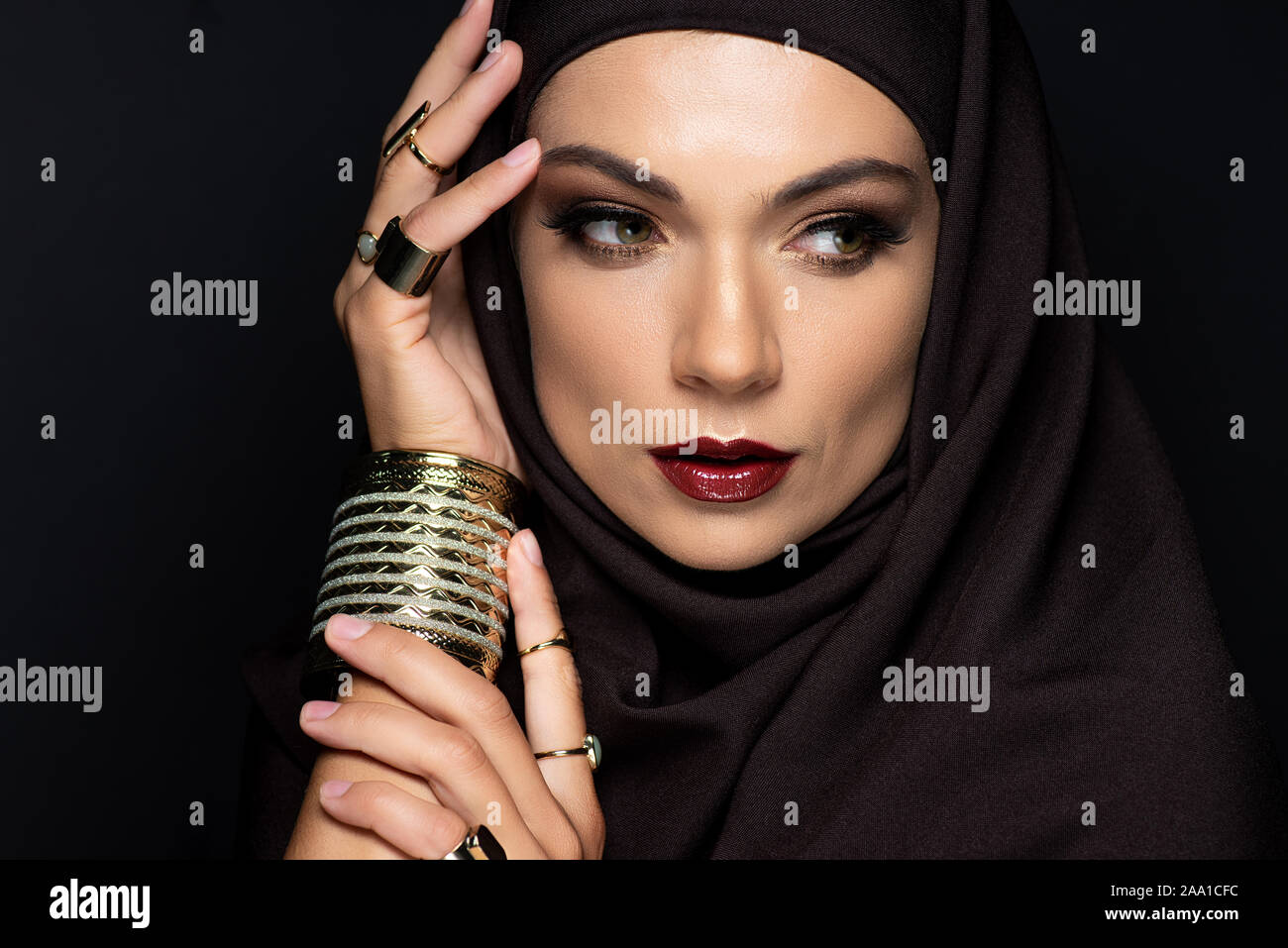 beautiful Muslim woman in hijab with makeup in golden rings and ...