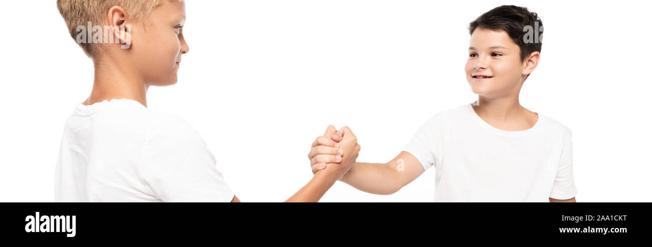 panoramic shot of smiling brothers holding hands isolated on white ...