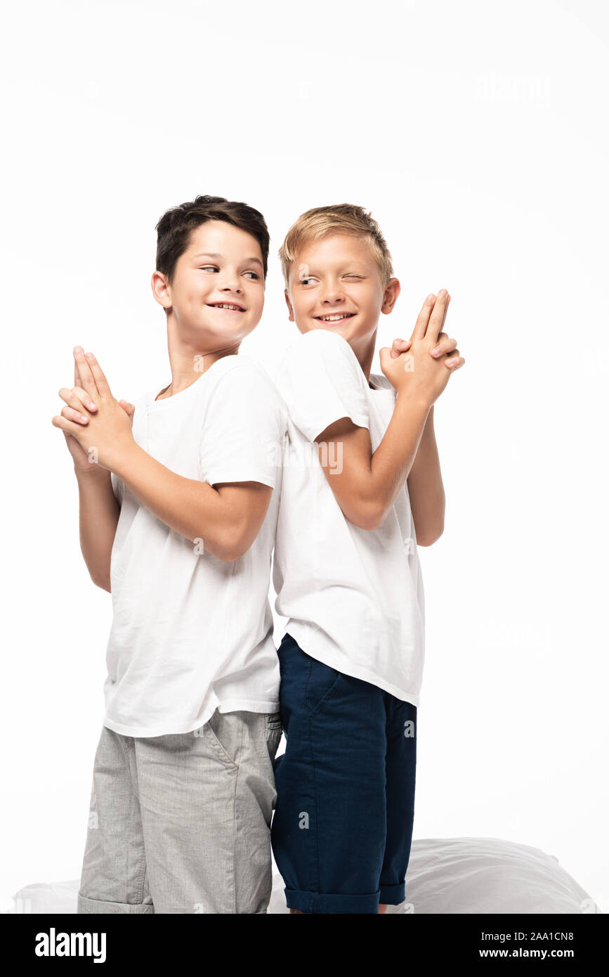 two cheerful brothers standing back to back and showing gun gestures ...