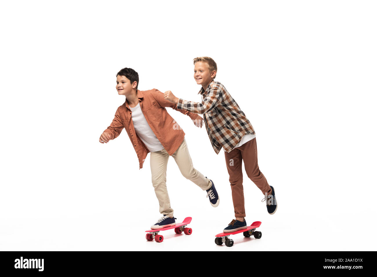 two happy brothers riding penny boards on white background Stock Photo ...