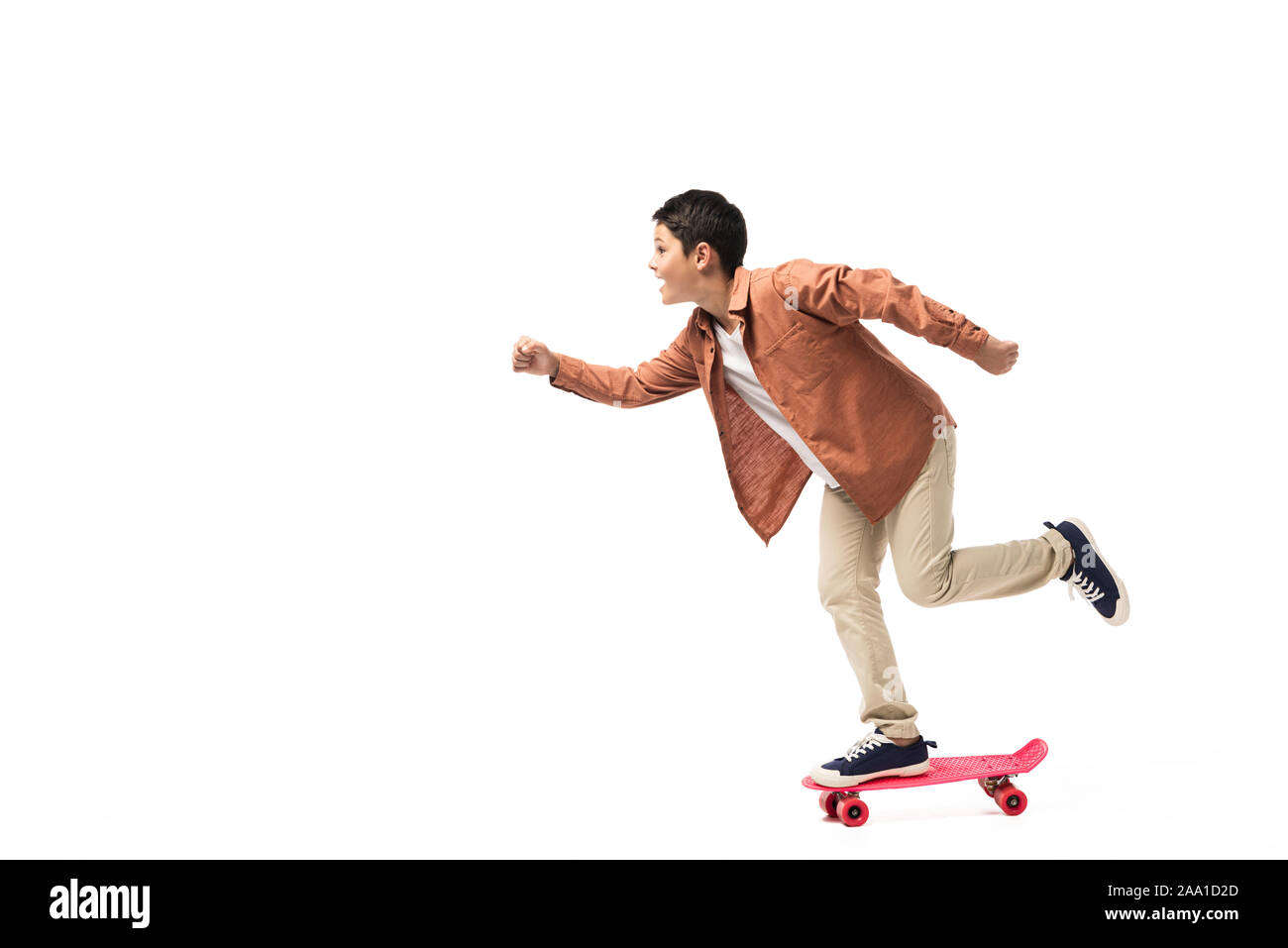 side view of cheerful boy riding kick scooter on white background Stock ...