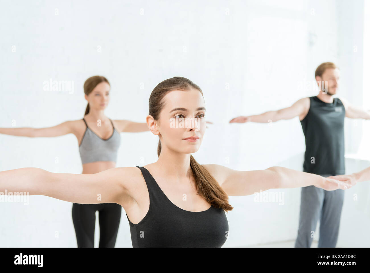 young women and man practicing yoga in mountain open arm pose Stock ...