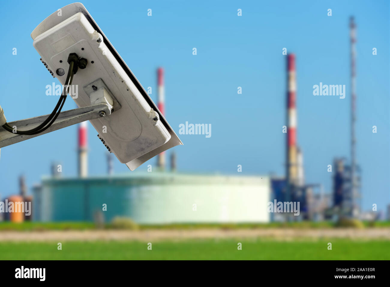 CCTV camera concept with fuzzy oil storage tanks on blurry background ...