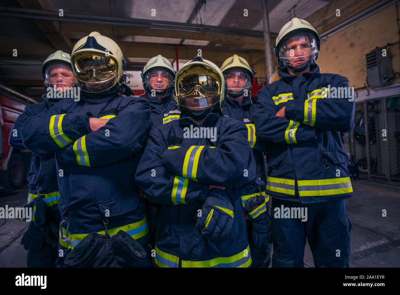Portrait of group firefighters in front of firetruck inside the fire ...
