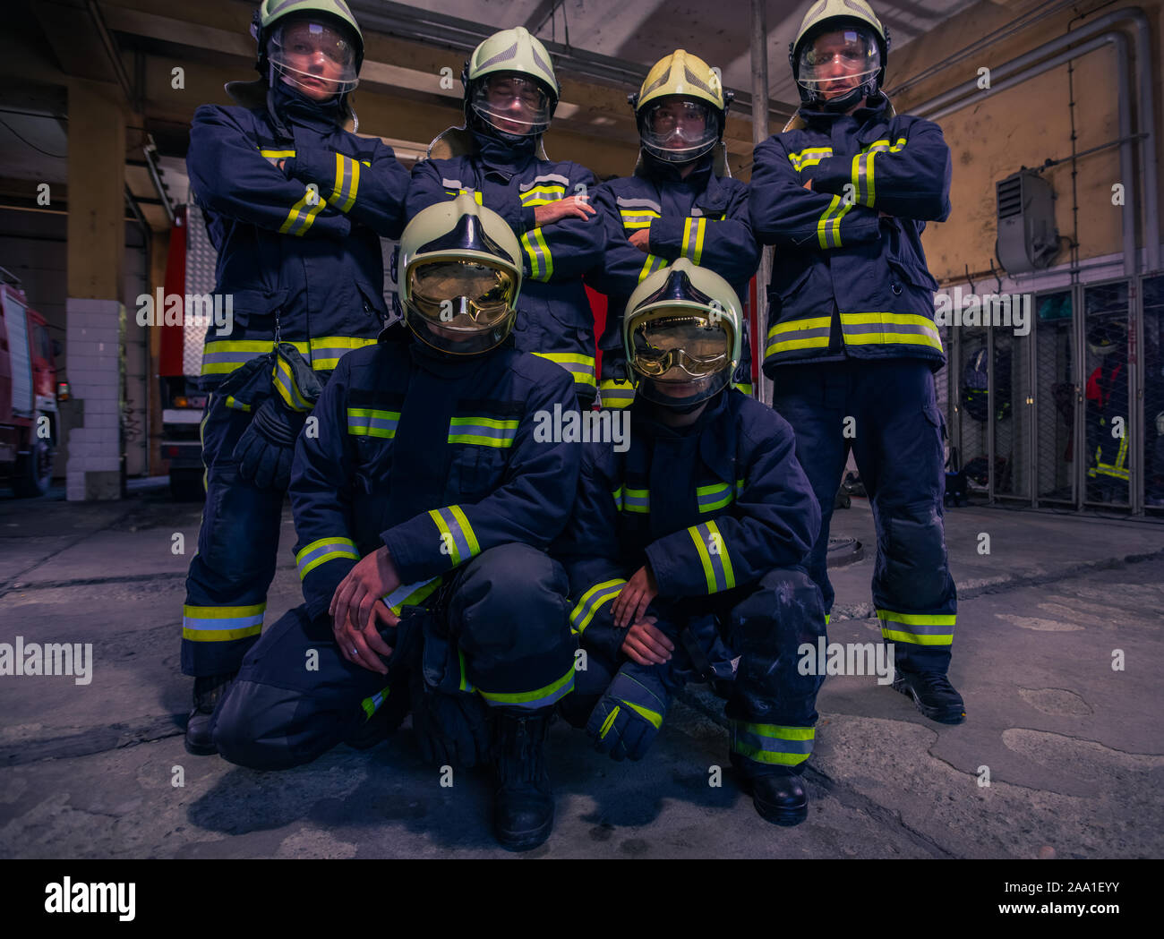 Portrait of group firefighters in front of firetruck inside the fire ...