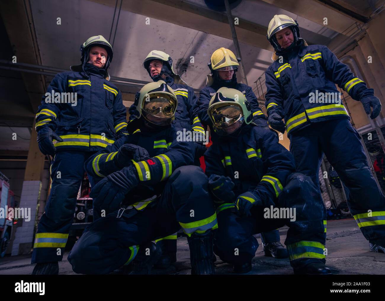 Portrait of group firefighters in front of firetruck inside the fire ...
