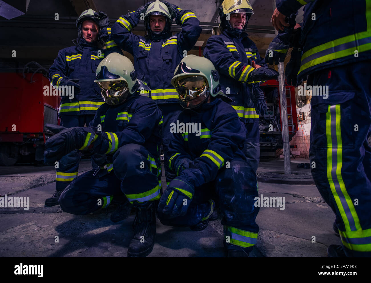 Portrait of group firefighters in front of firetruck inside the fire ...