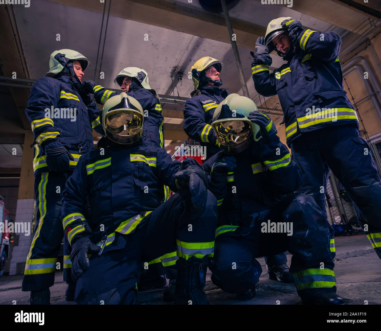 Portrait of group firefighters in front of firetruck inside the fire ...
