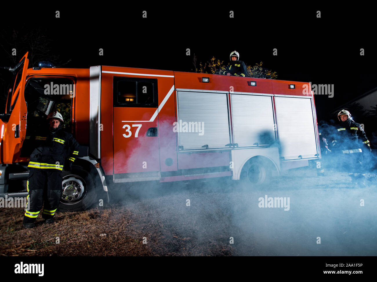 Firemen preparing the fire truck equipment for extinguishing flames ...