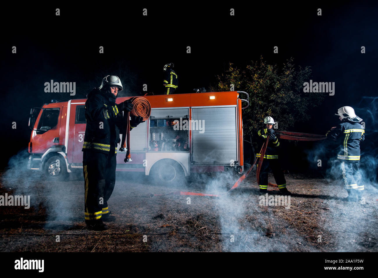 Firemen outfitted with gear during a firefighting operation Stock Photo ...