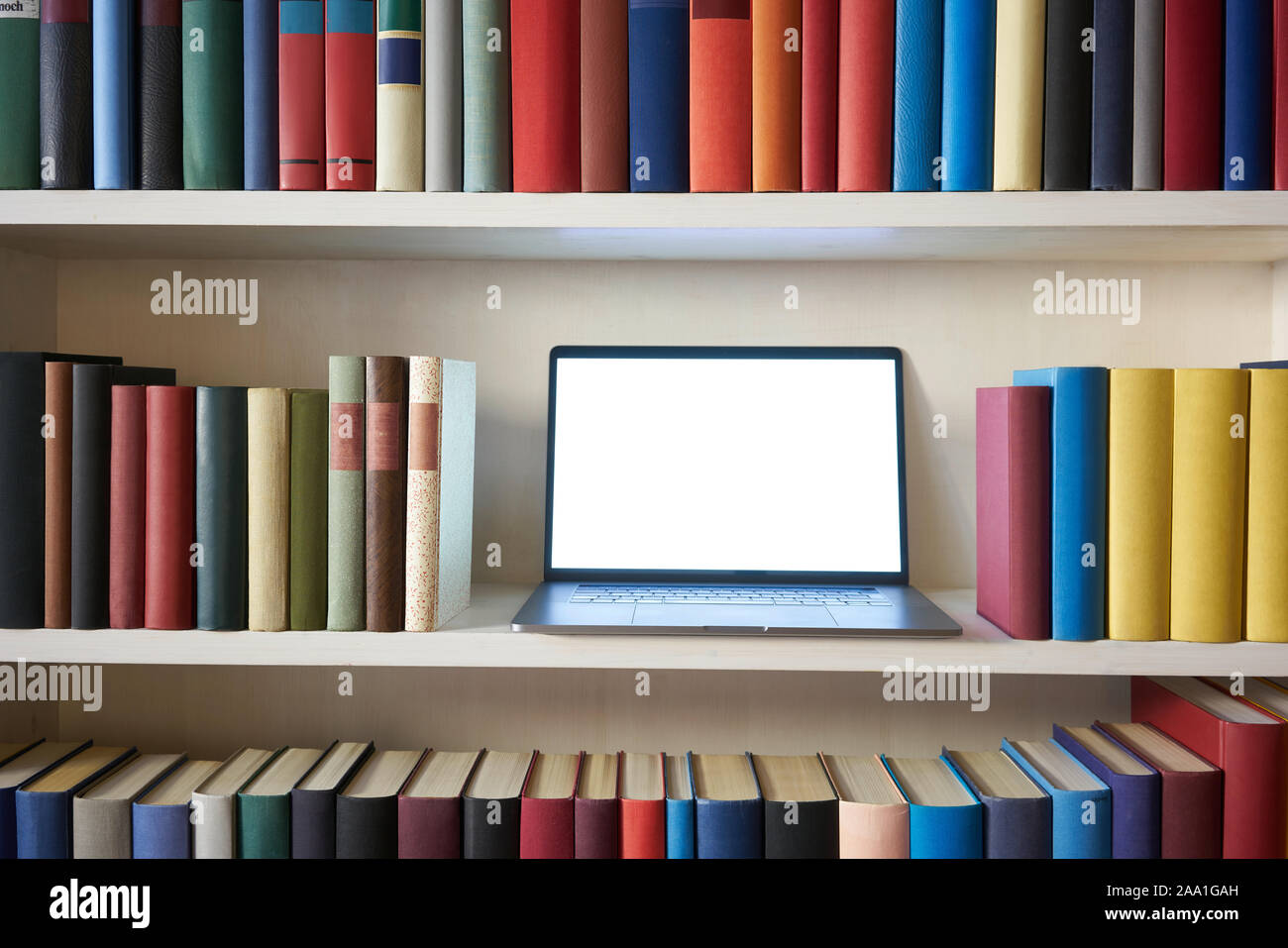 Computer technology in colorful bookcase Stock Photo - Alamy