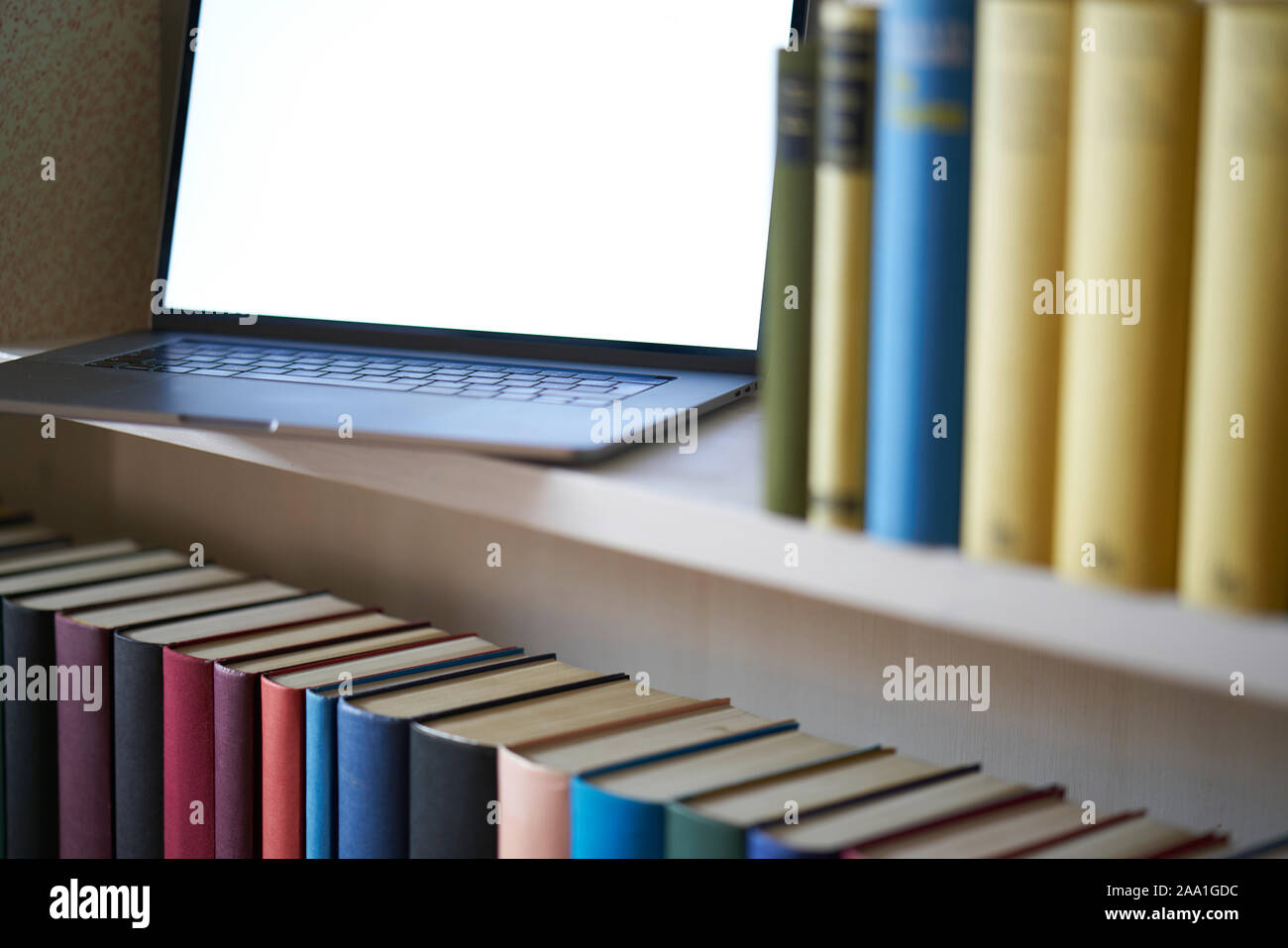 Close up of computer in bookcase Stock Photo - Alamy