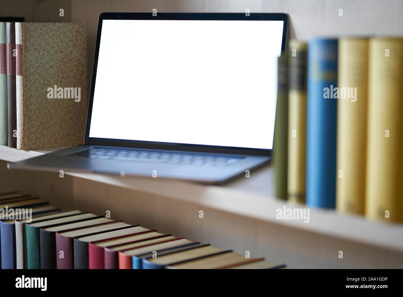 Close up of computer in bookcase Stock Photo - Alamy